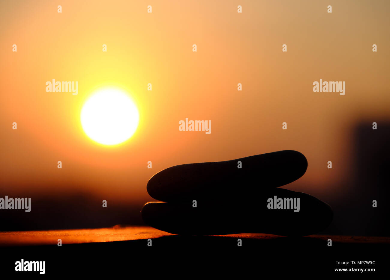 Amazing shape of stack of pebble on yellow sun background at sunrise ...
