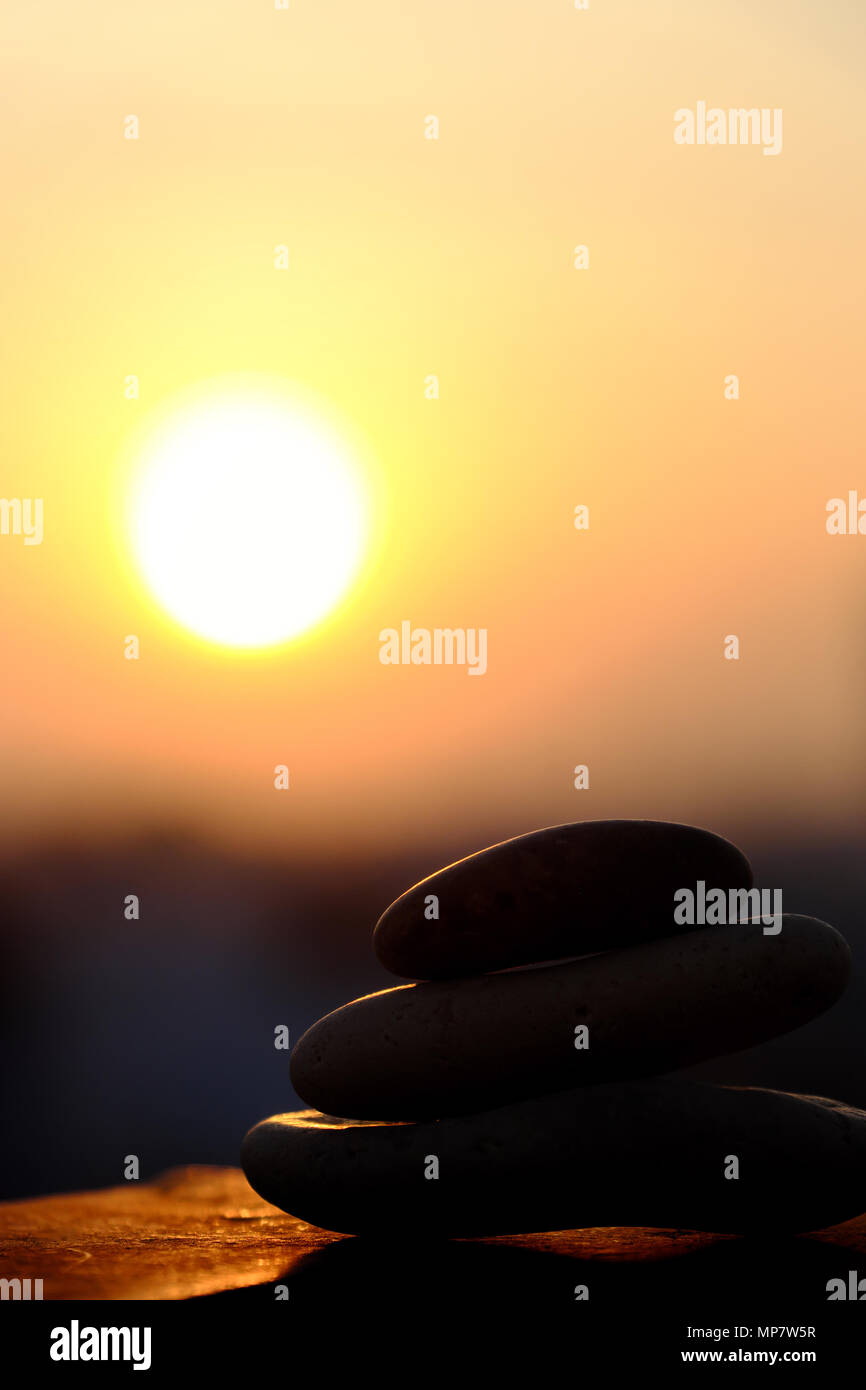 Amazing shape of stack of pebble on yellow sun background at sunrise ...