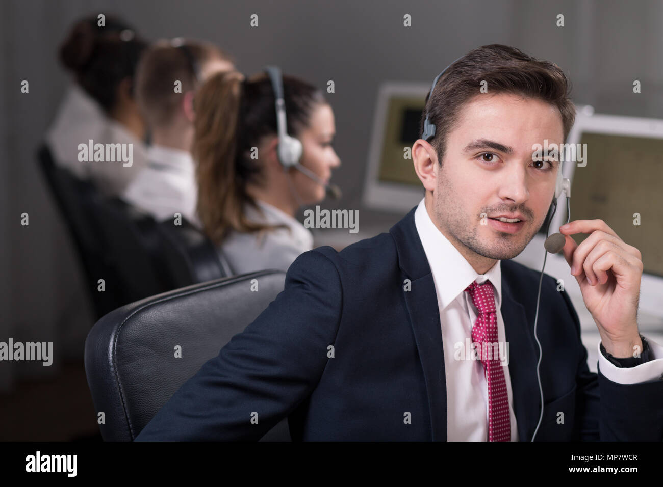 Shot of a young professional call center agent listening carefully to ...