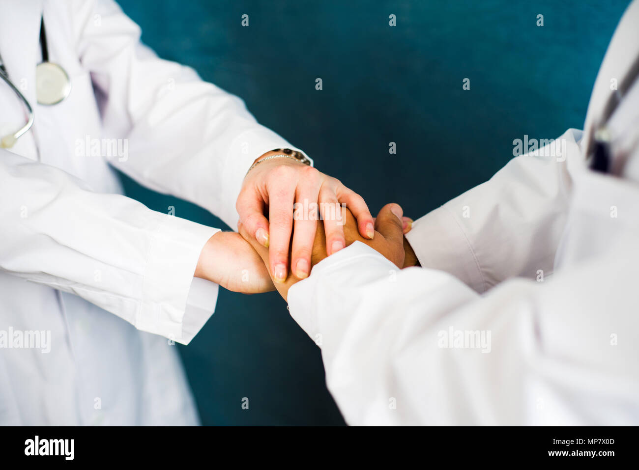 Two doctors putting their hands on top of each other Stock Photo - Alamy