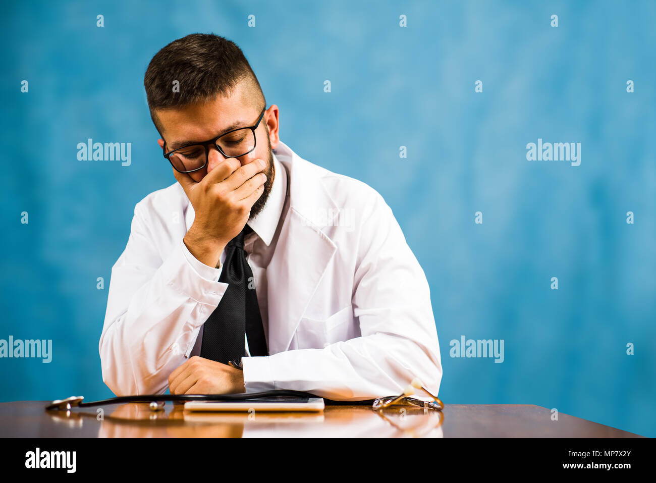 Worried doctor showing concern and regret on the table Stock Photo - Alamy