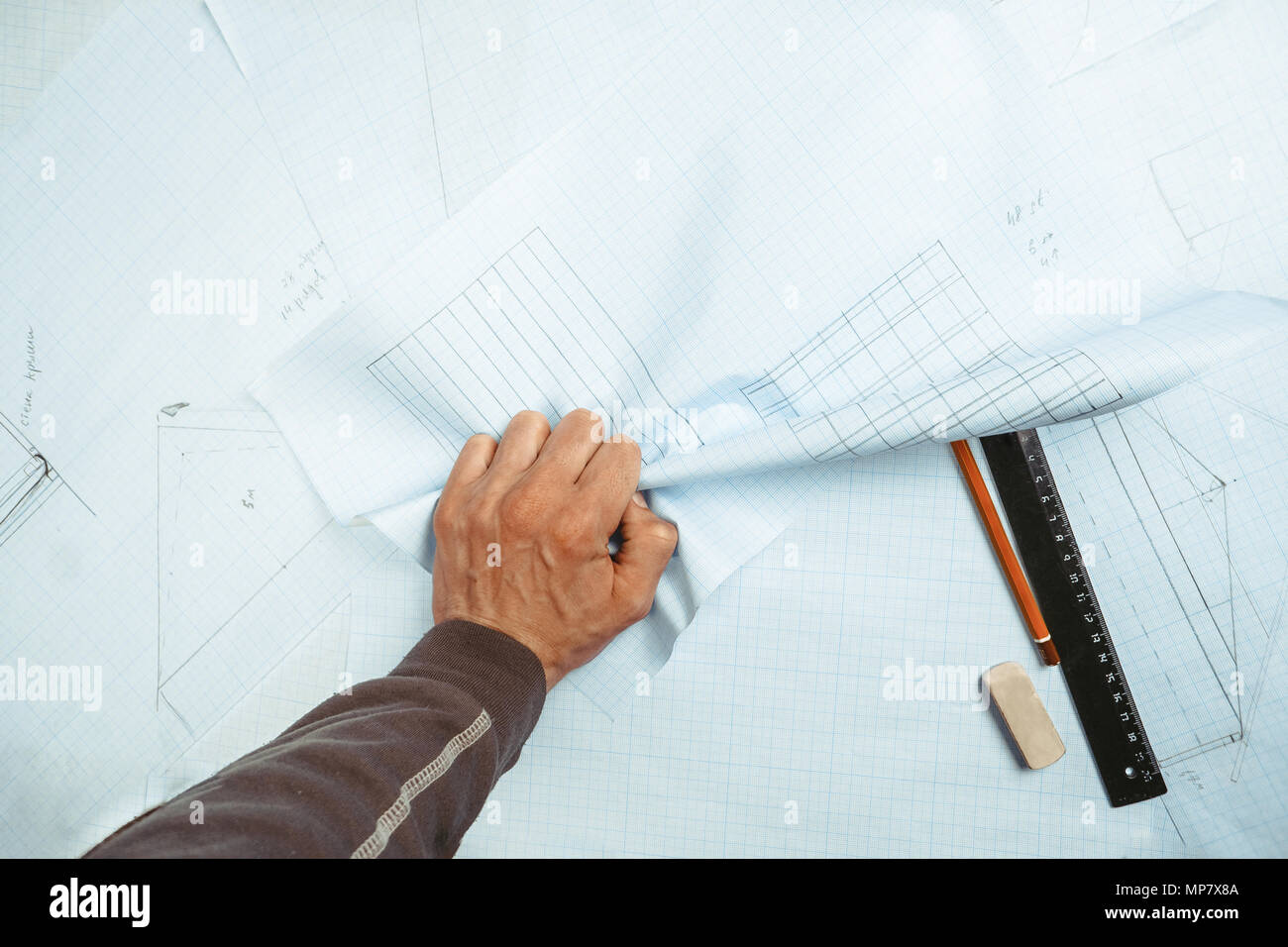 hand crumples the paper over the table where are the drawings Stock ...