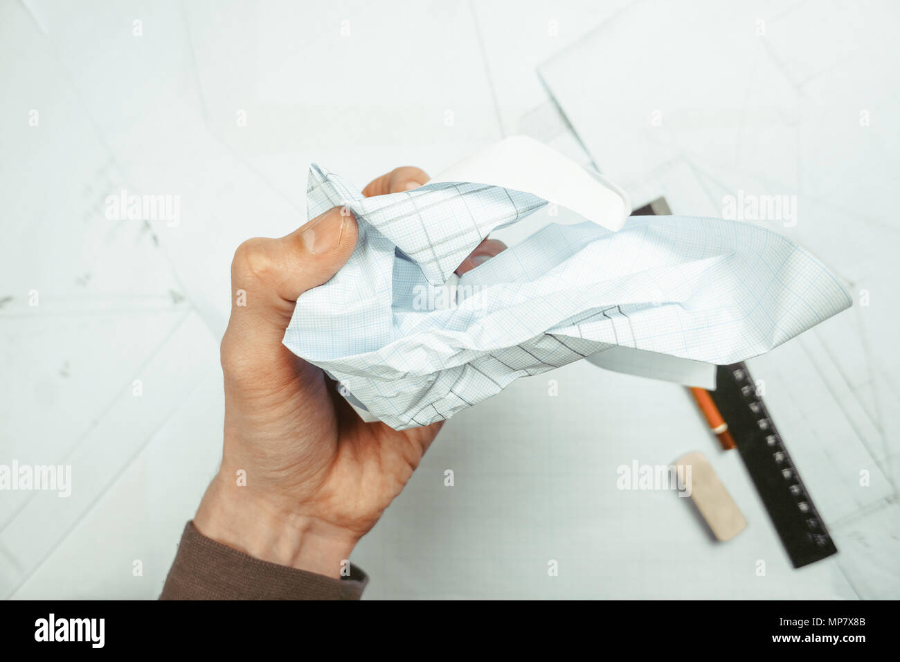 hand crumples the paper over the table where are the drawings Stock ...