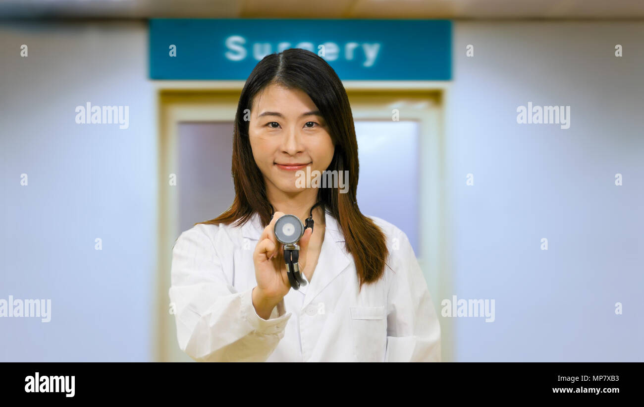 Chinese female doctor by hospital surgery holding out stethoscope ...