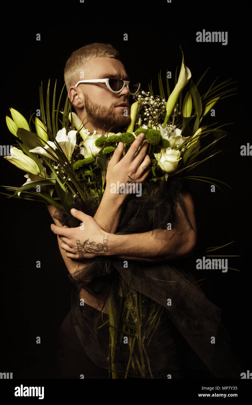 Stylish man whith white flowers bouquet on black background Stock Photo ...