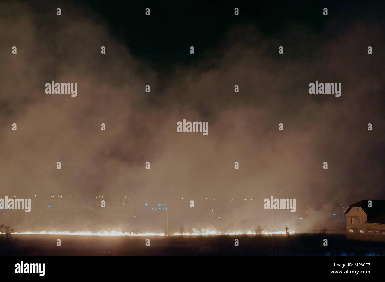 the smoke from the burning field, fire in the field at night, burning ...