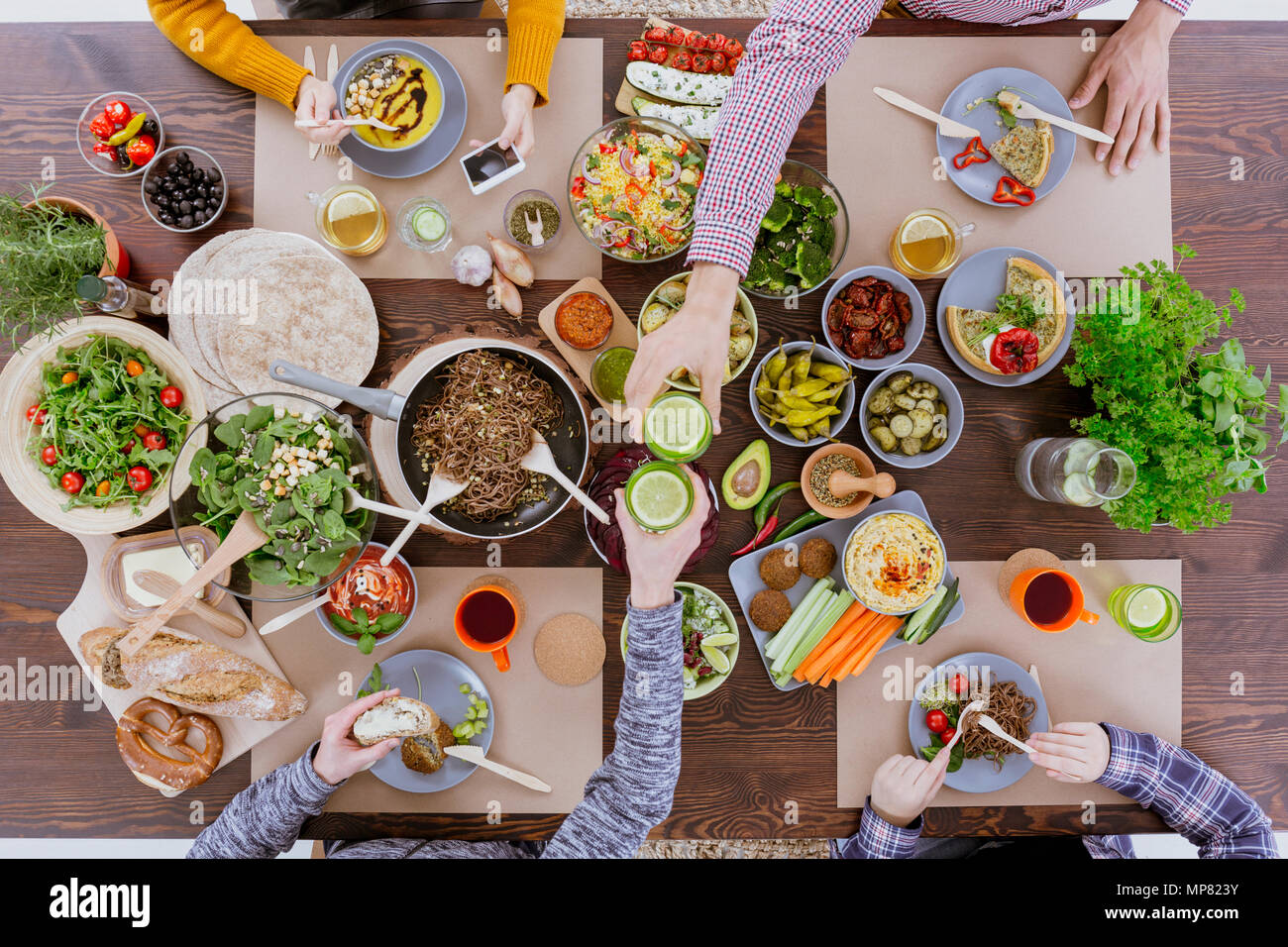 People cheering during healthy dinner, sitting at rustic table Stock ...