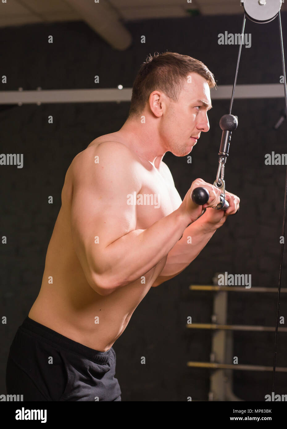 Strong muscular bodybuilder doing exercise in the gym. Fitness training ...