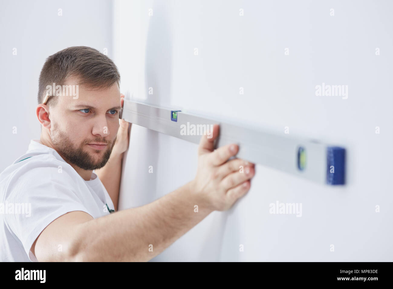 Male specialist in home renovation checking the wall with spirit level ...