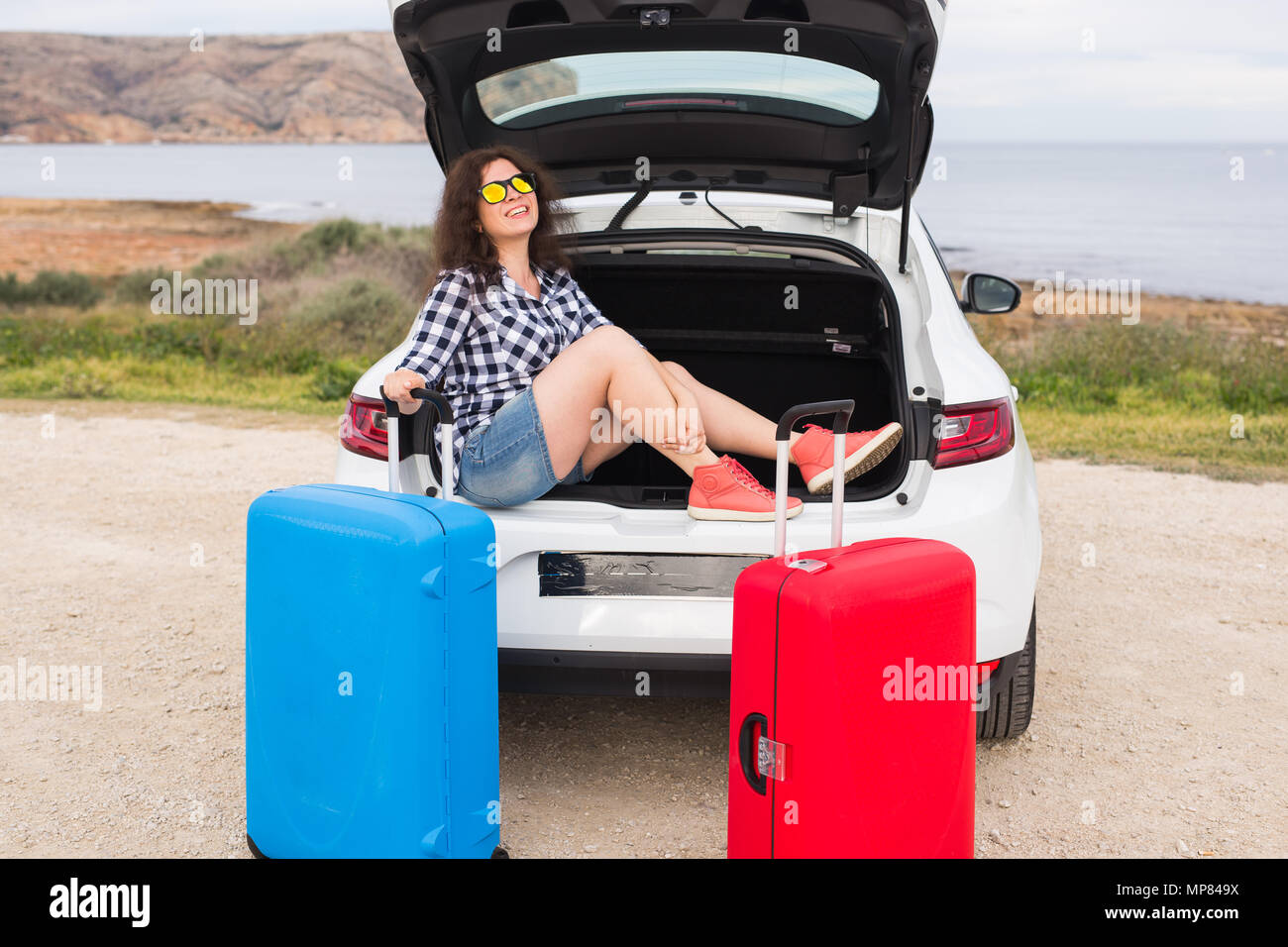 Young woman sitting in back of car smiling and getting ready to go ...
