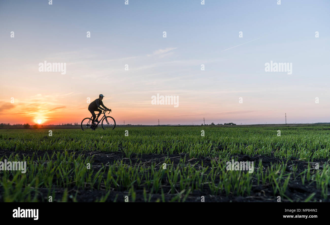 Man ride a bicycle in sunset. Riding a Bicycle at Sunset. Healthy ...