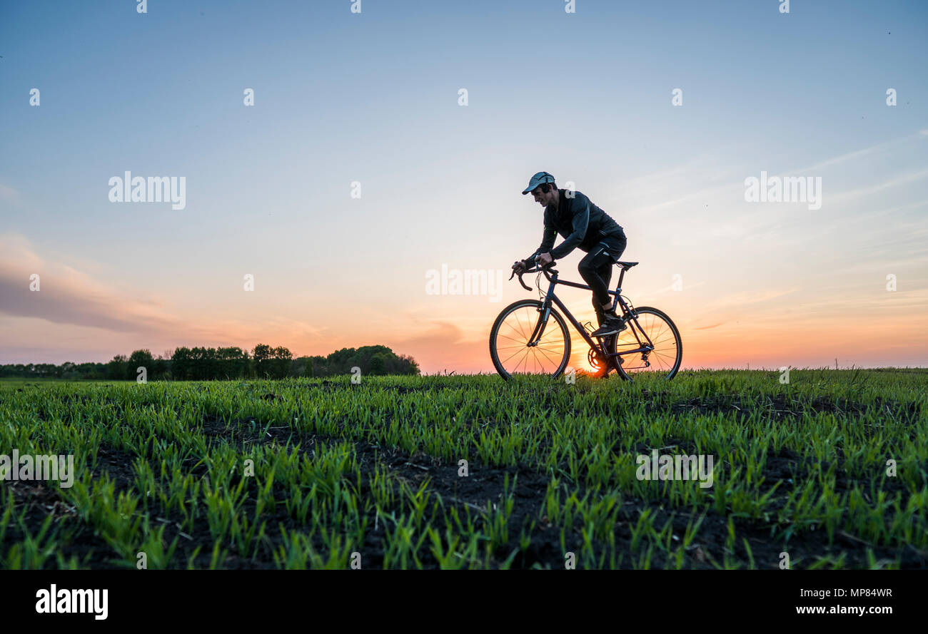 Man ride a bicycle in sunset. Riding a Bicycle at Sunset. Healthy ...