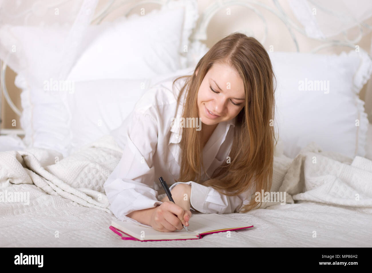 Girl writes a diary while lying in bed in the morning Stock Photo - Alamy