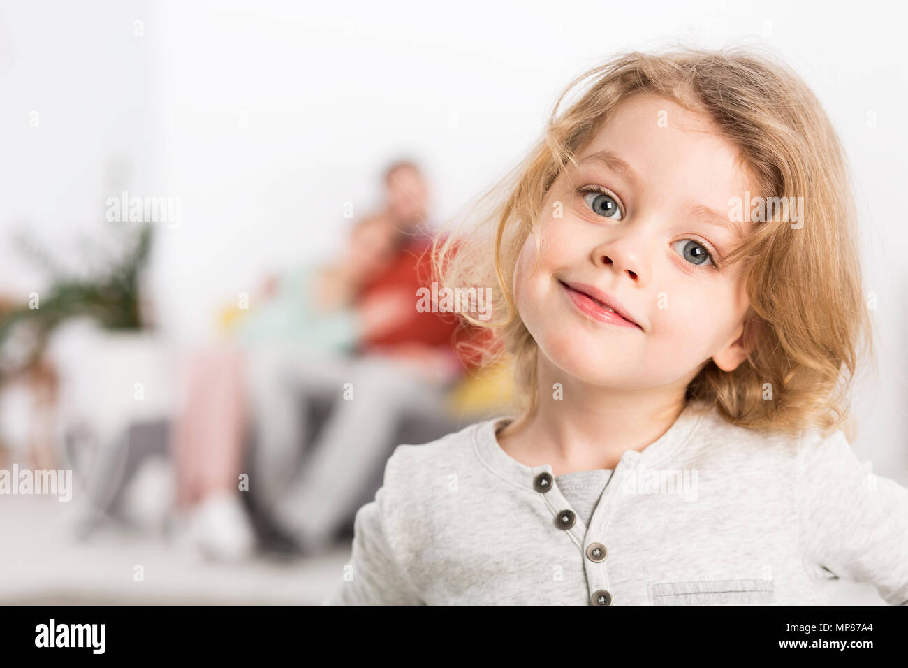 Optimistic portrait of a little blonde boy with a cheery smile, with ...