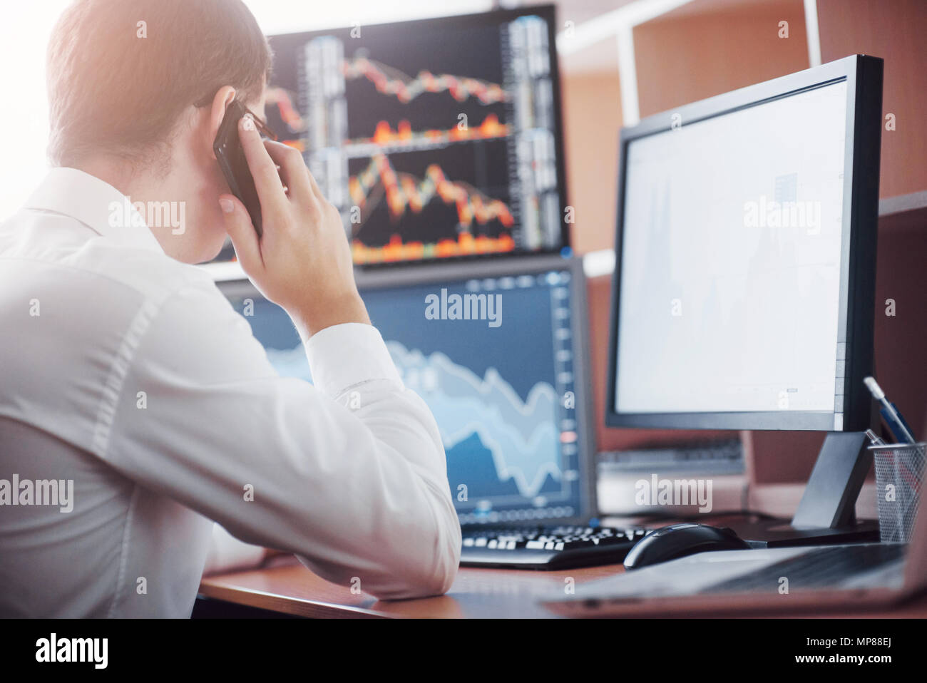 Over the shoulder view of and stock broker trading online while ...