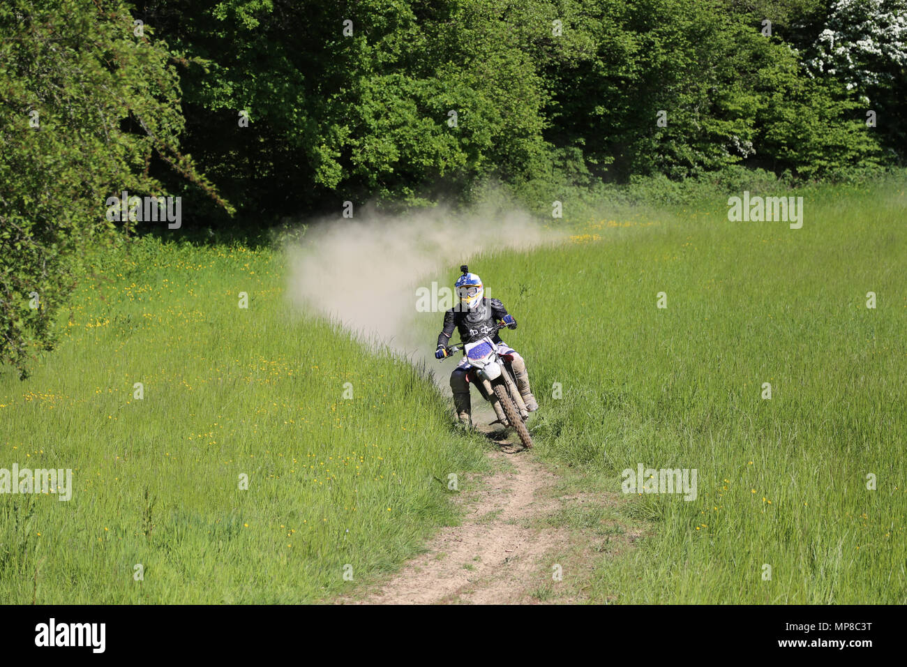 Man riding motocross motorcycle through field Stock Photo - Alamy