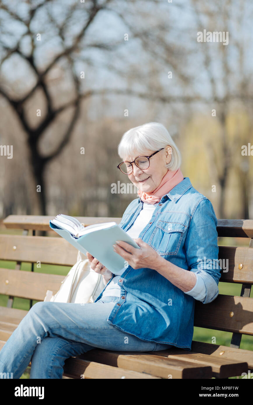 Delighted old woman reading a book Stock Photo - Alamy
