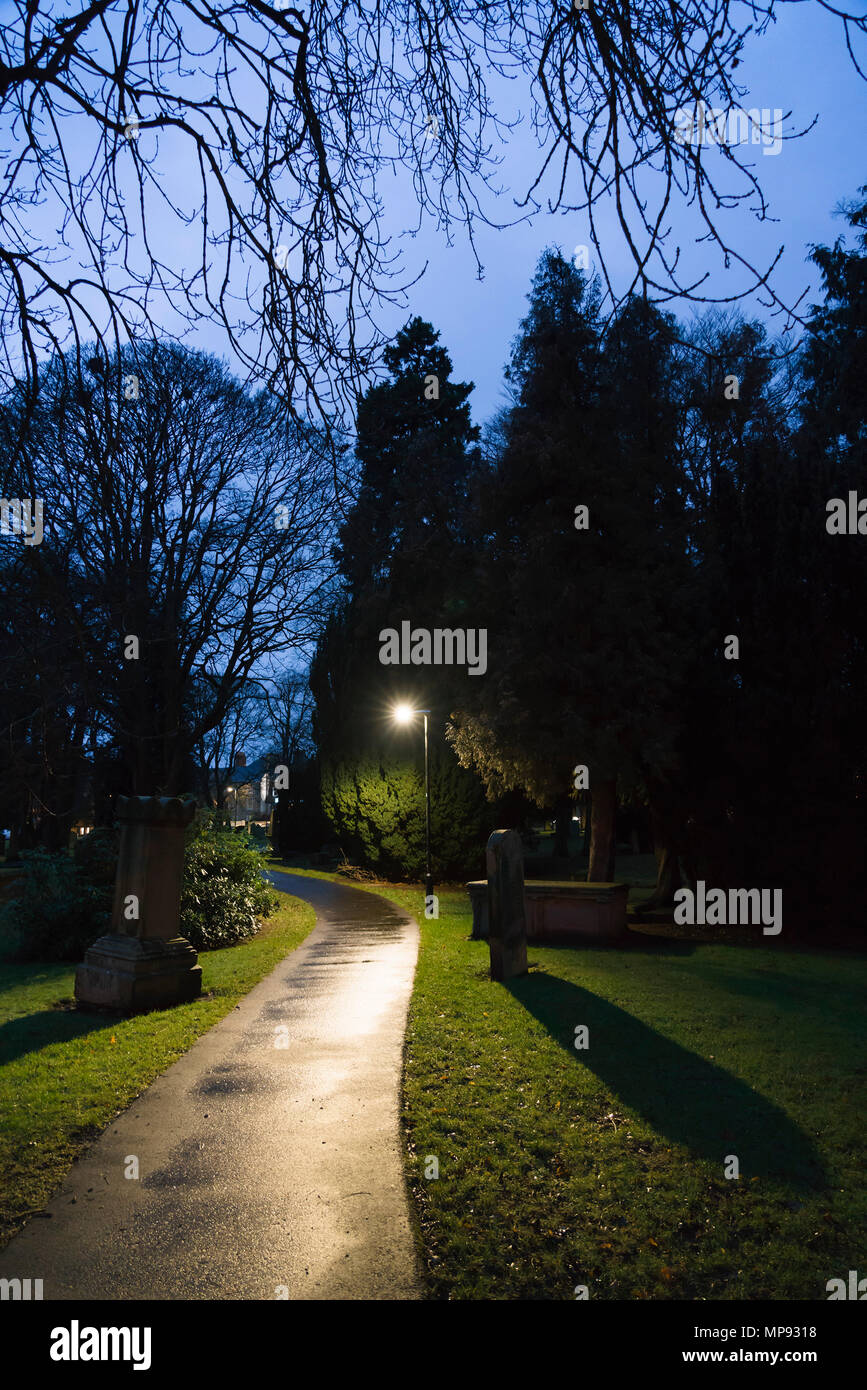 In Kelso churchyard, Scotland. At night. A path between the graves ...