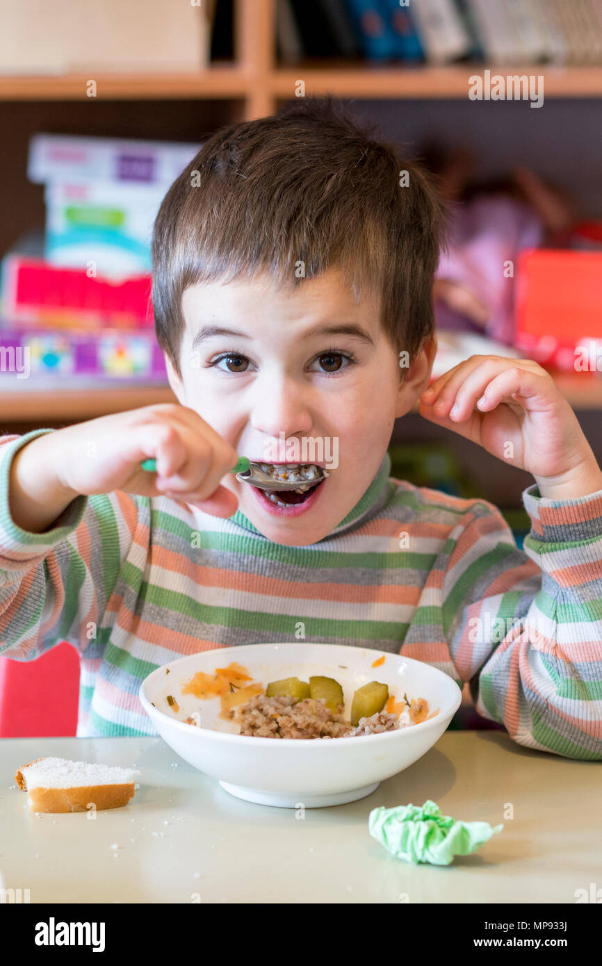 A boy at the age of 5 years eating gruel in the kindergarten Stock ...