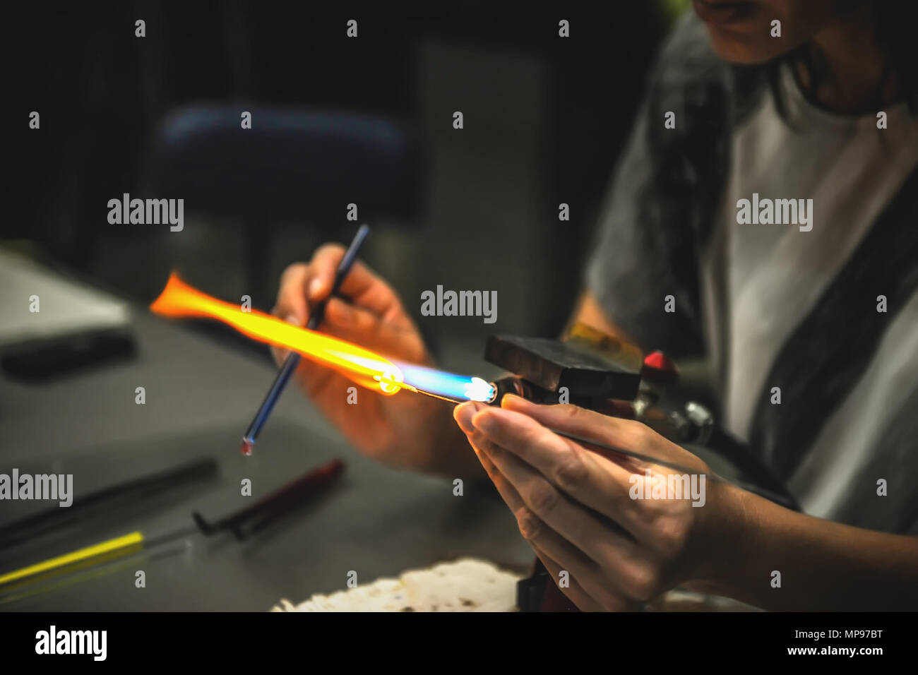 The process of blowing glass products. The manufacture of beads. Hands ...