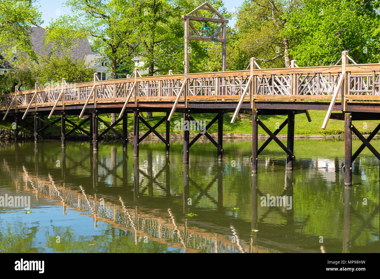Wooden bridge over Spring Lake is reflected in the lake below Stock ...