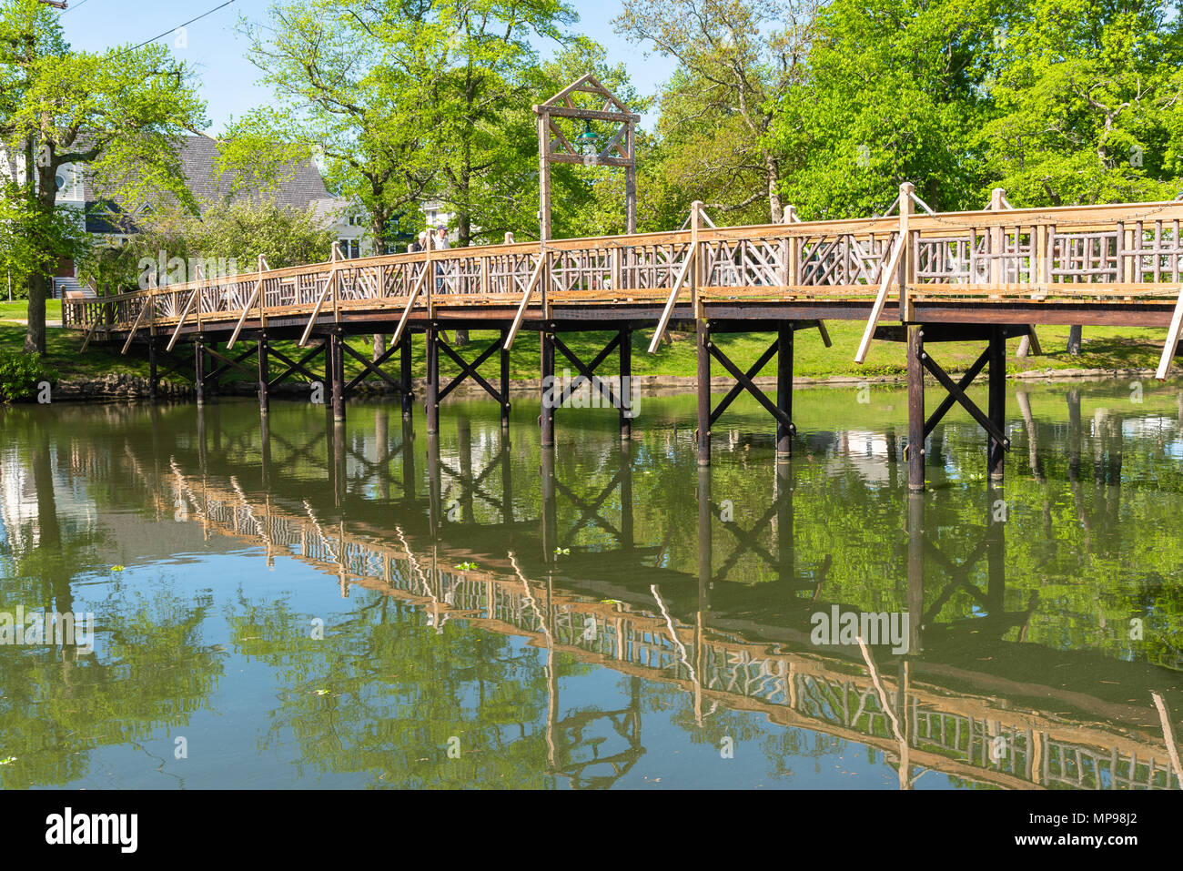 Wooden bridge over Spring Lake is reflected in the lake below Stock ...
