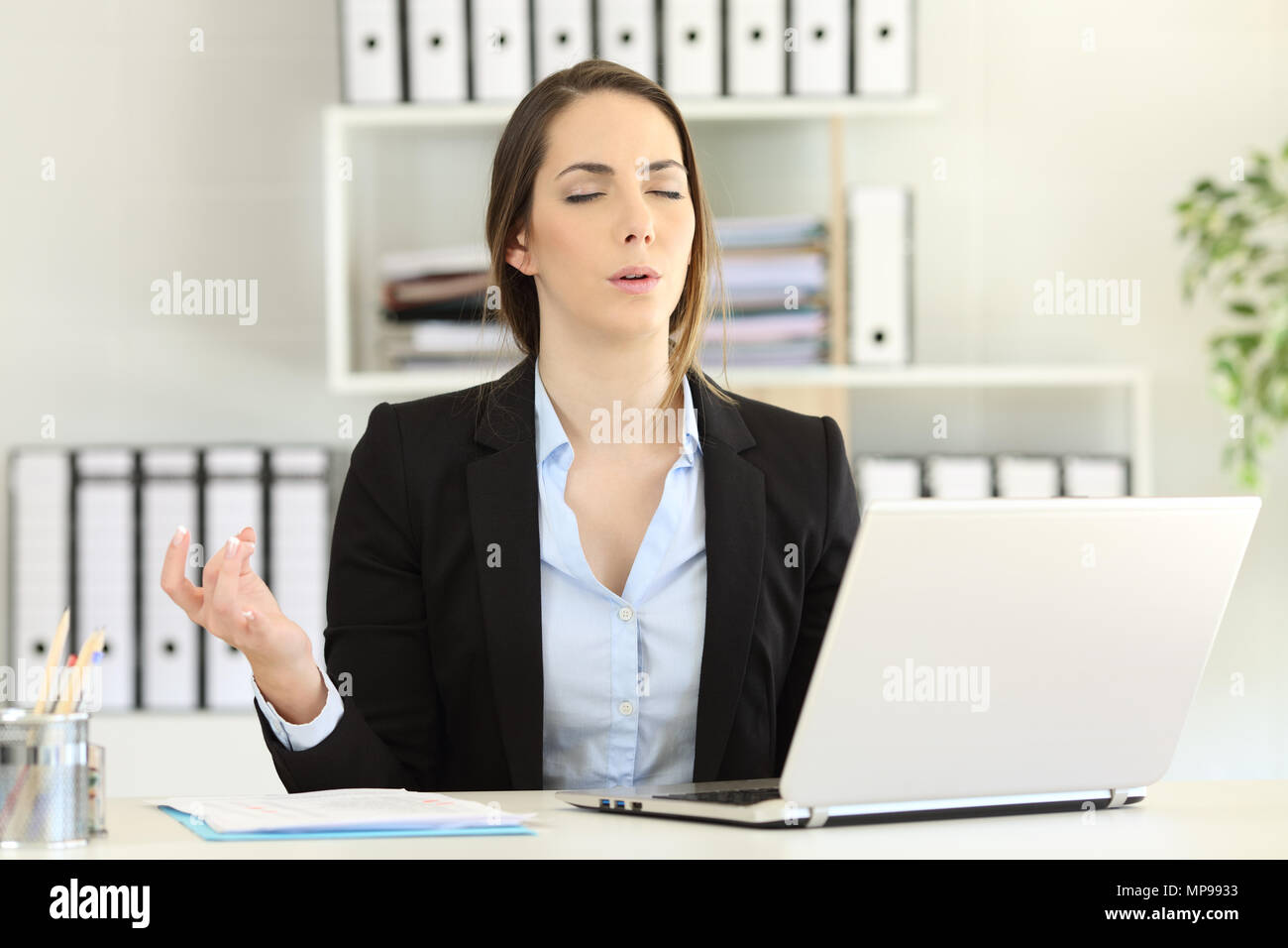 Stressed executive trying to relax doing yoga at office Stock Photo - Alamy
