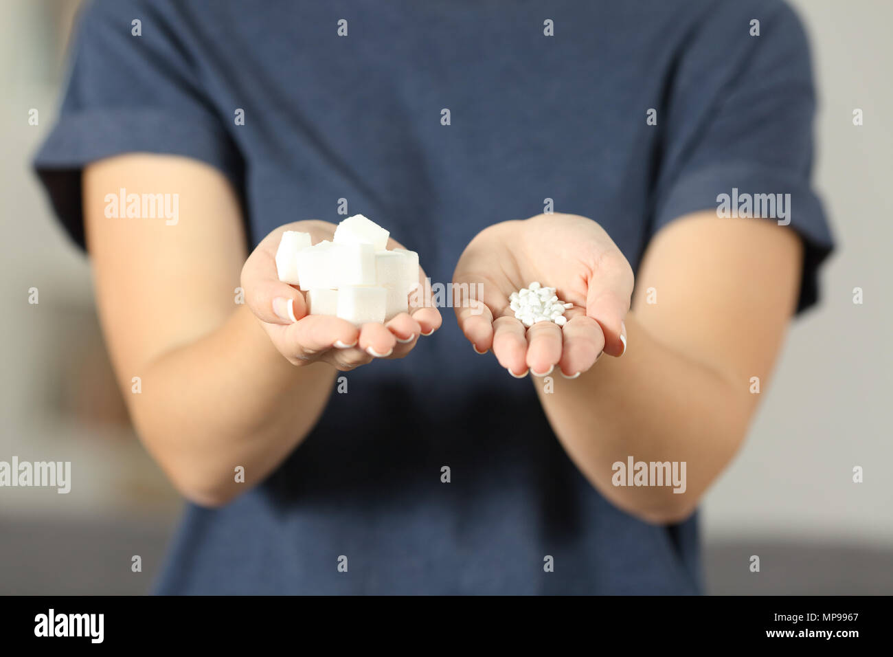 Front view close up of a woman hands holding sugar cubes and saccharin ...