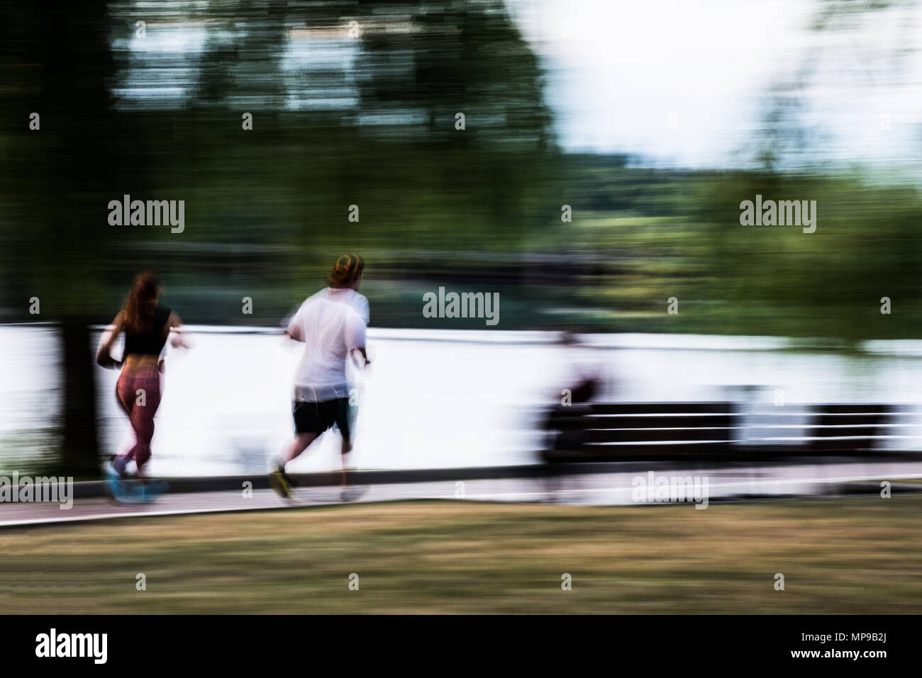 Blurred running couple of athletes in the park Stock Photo - Alamy