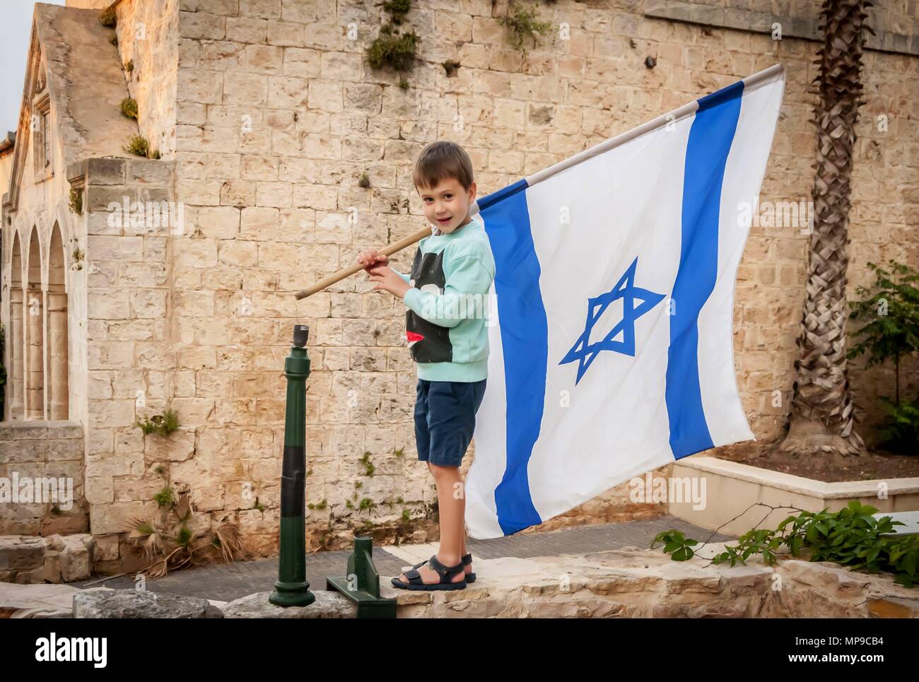Cute Caucasian Jewish boy with a large flag of Israel in his hands ...