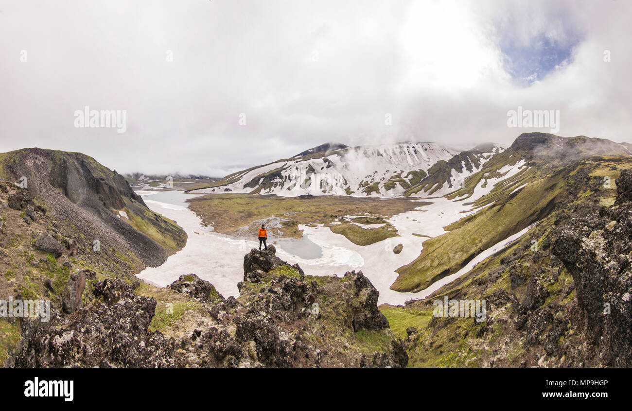 man standing on volcanic slag with view on snowy volcanoes Stock Photo ...