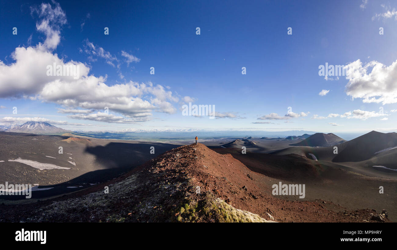 man standing on volcanic slag with view on snowy volcanoes Stock Photo ...