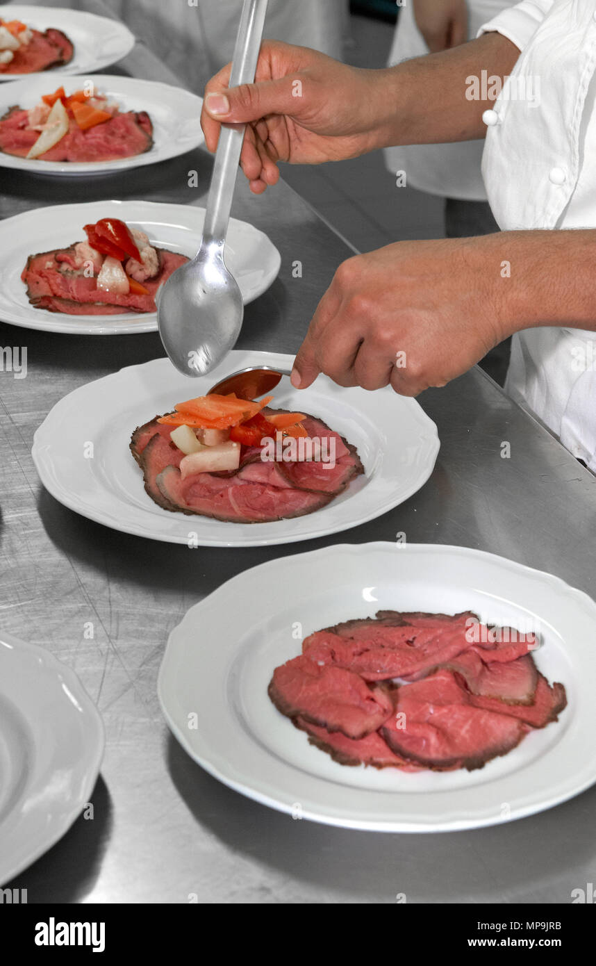 preparation of some dish with roast-beef in a kitchen of a restaurant ...