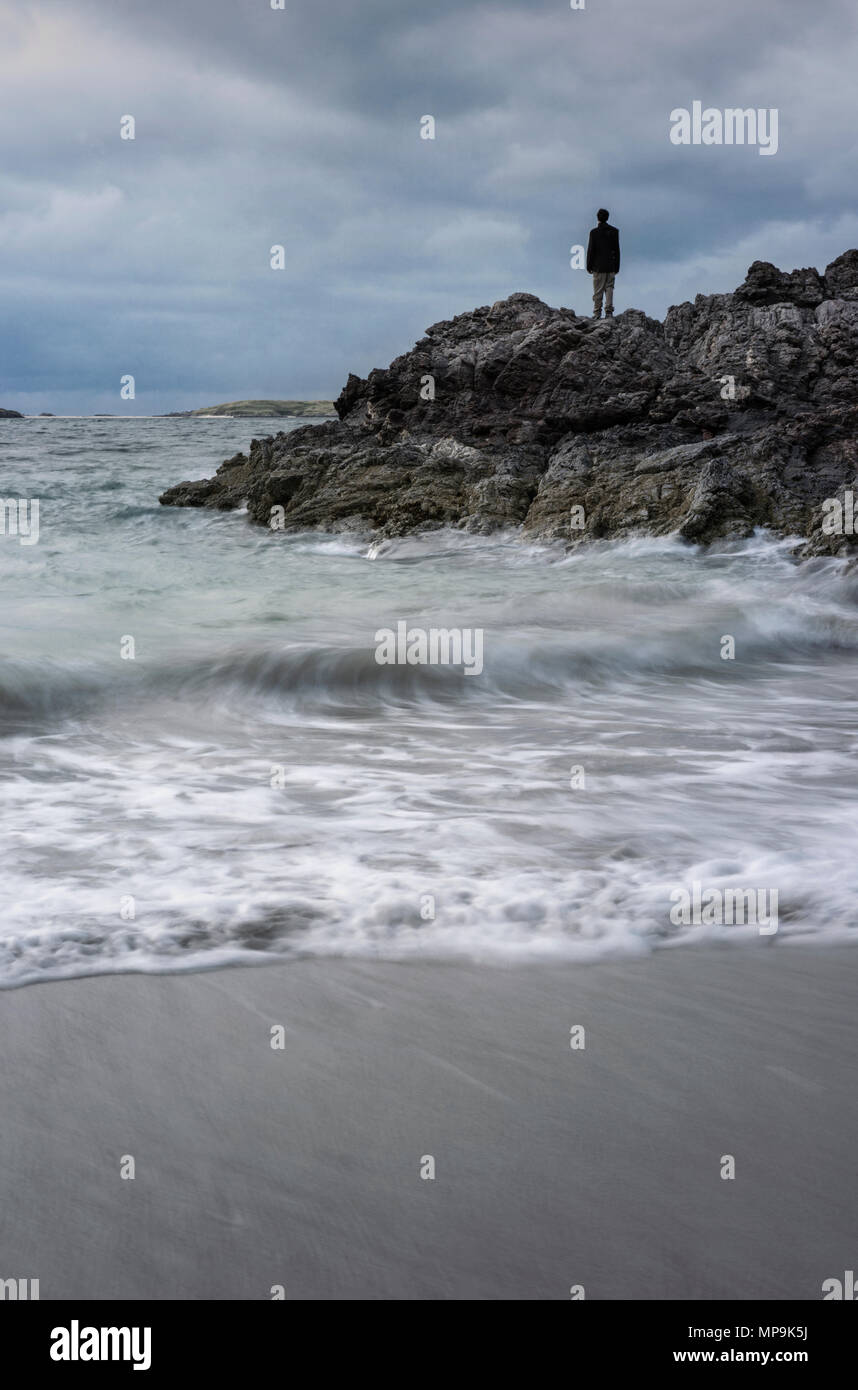 Teenage boy standing on the rocks at Coldbackie beach, Sutherland ...