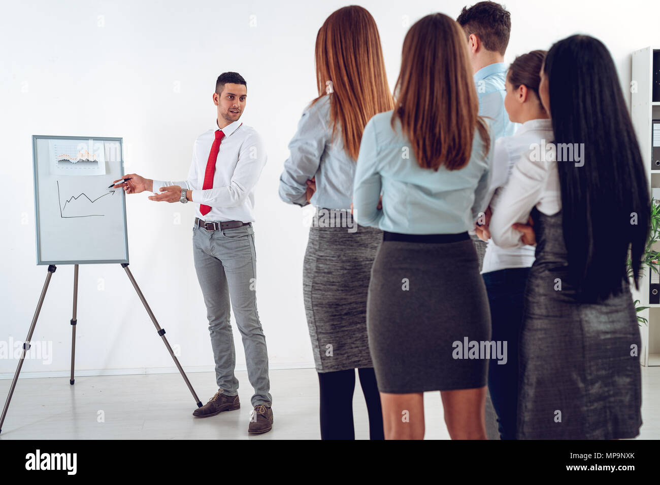 Businesspeople having meeting in a office. Young businessman standing ...