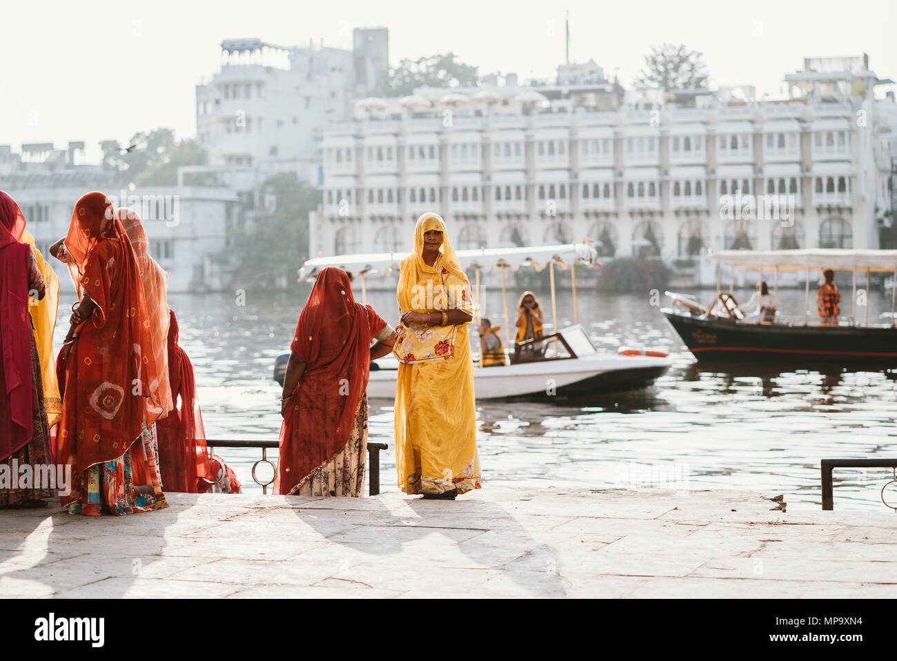 Beautiful and colorfully dressed Indian women mourn a death and wash ...