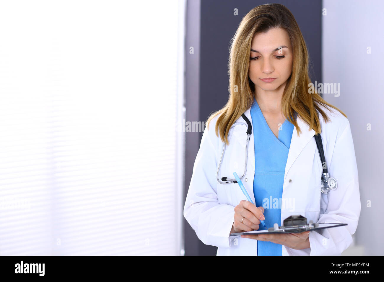 Woman doctor at work in hospital office. Portrait of female physician ...