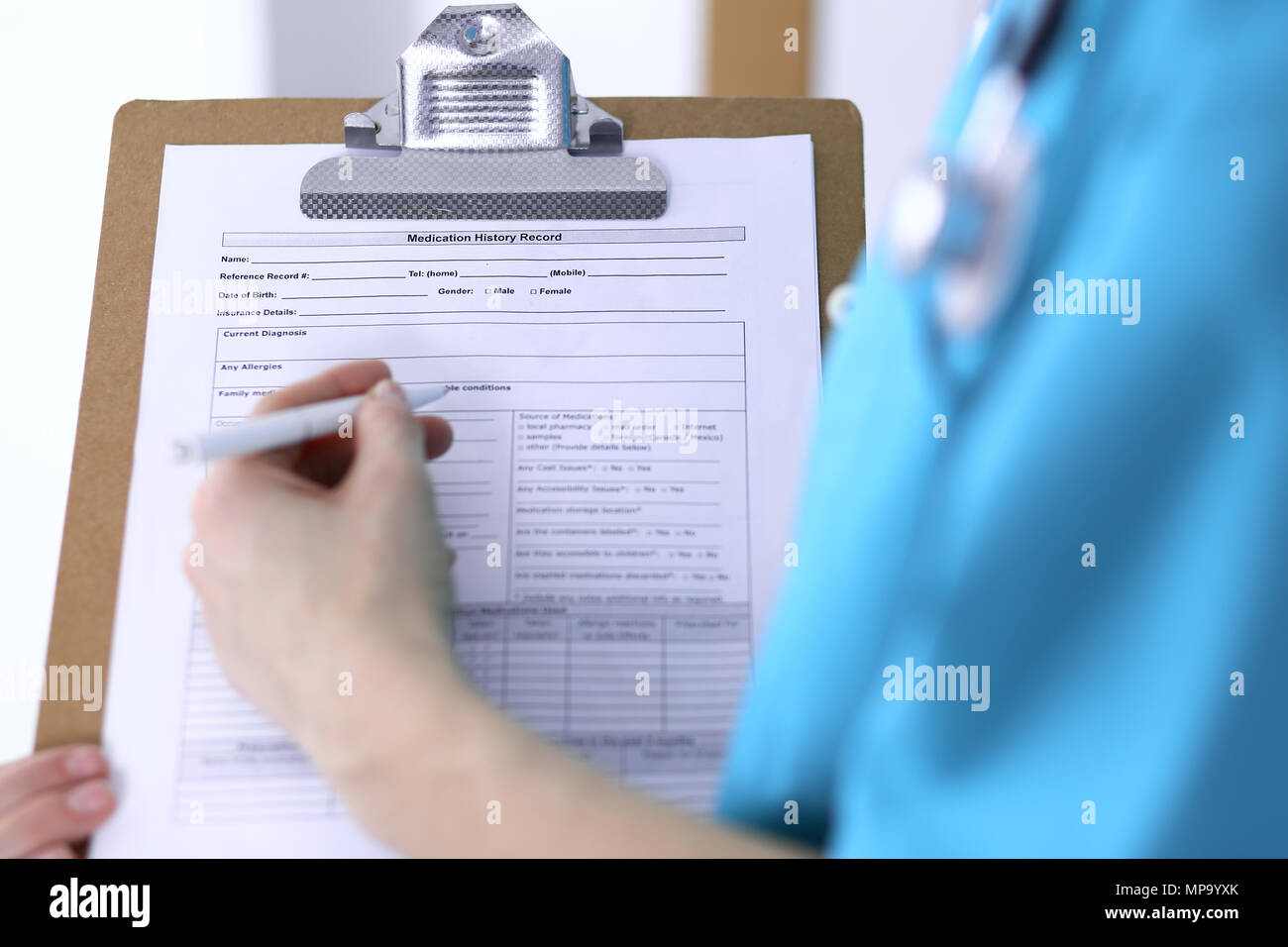 Female doctor filling up medical form on clipboard closeup. Physician ...