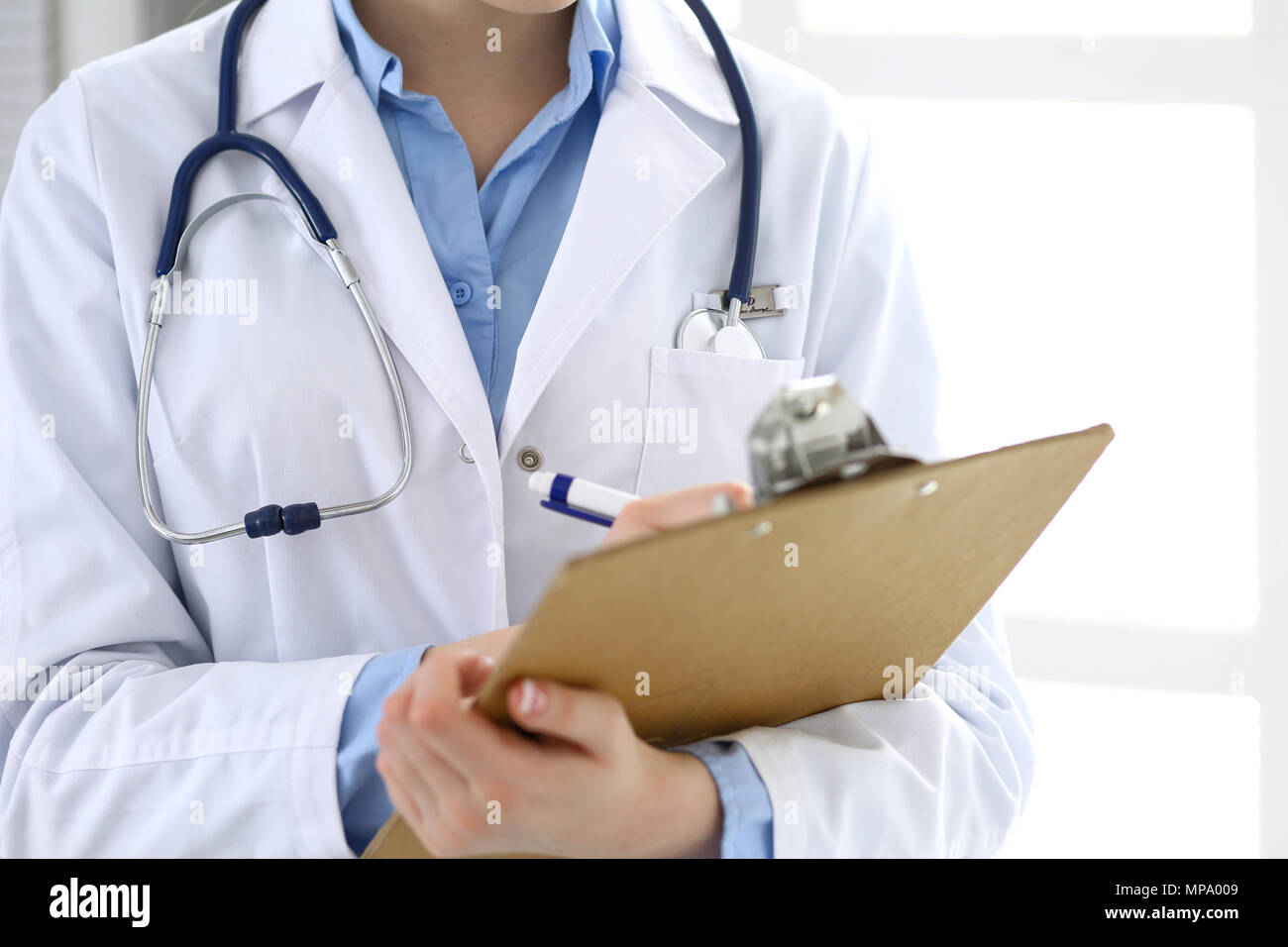 Female doctor filling up medical form on clipboard closeup. Healthcare ...