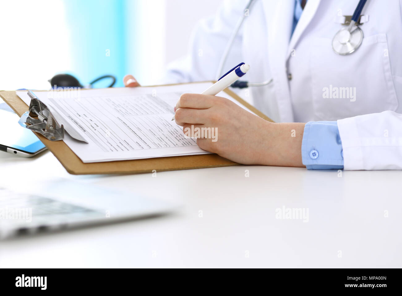 Female doctor filling up medical form on clipboard closeup. Healthcare ...