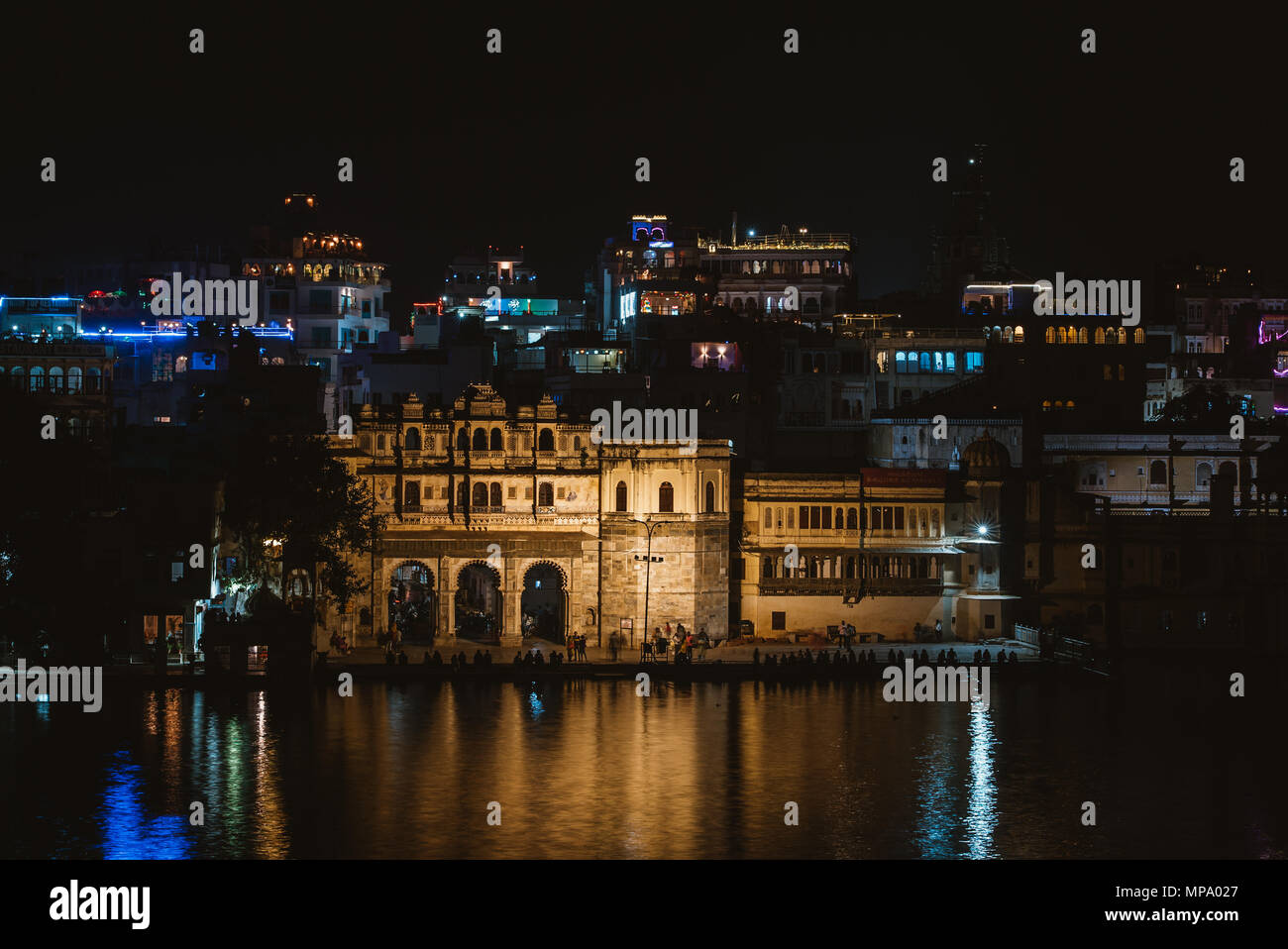 a building lit up at night on the waterfront in Udaipur, India Stock ...