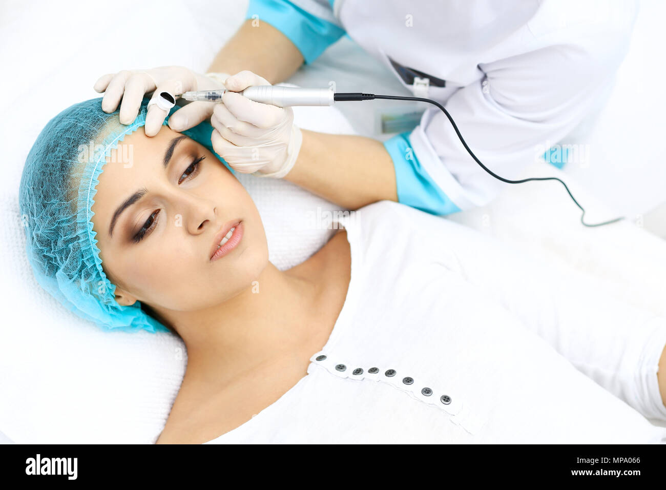 Professional beautician doing eyebrow tattoo at woman face. Permanent ...