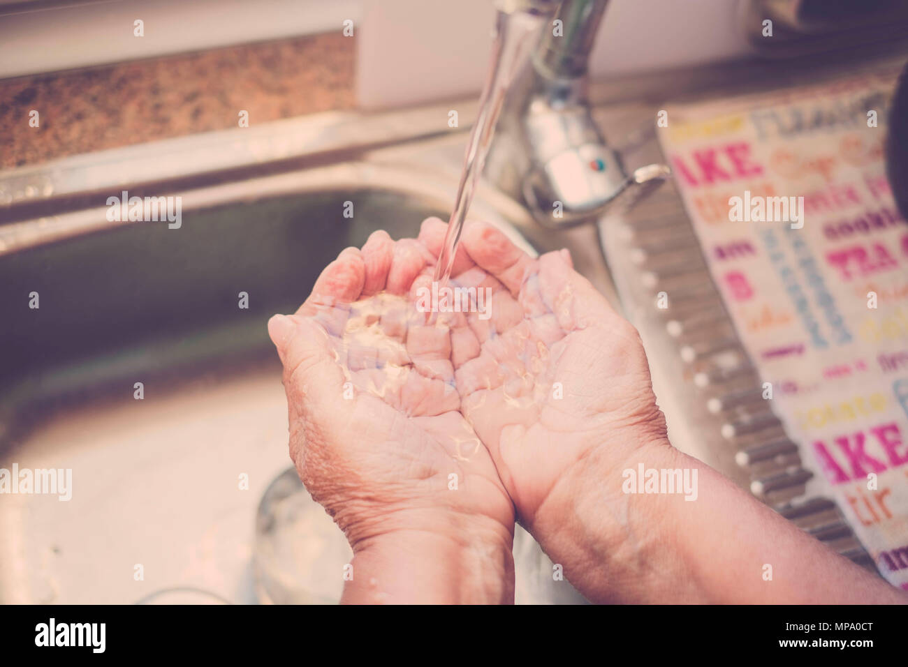 washing hands in the kitchen with clear water for old woman 70 years ...