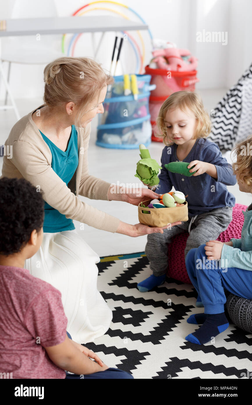 Little kids having fun with plush toys in kindergarten Stock Photo - Alamy