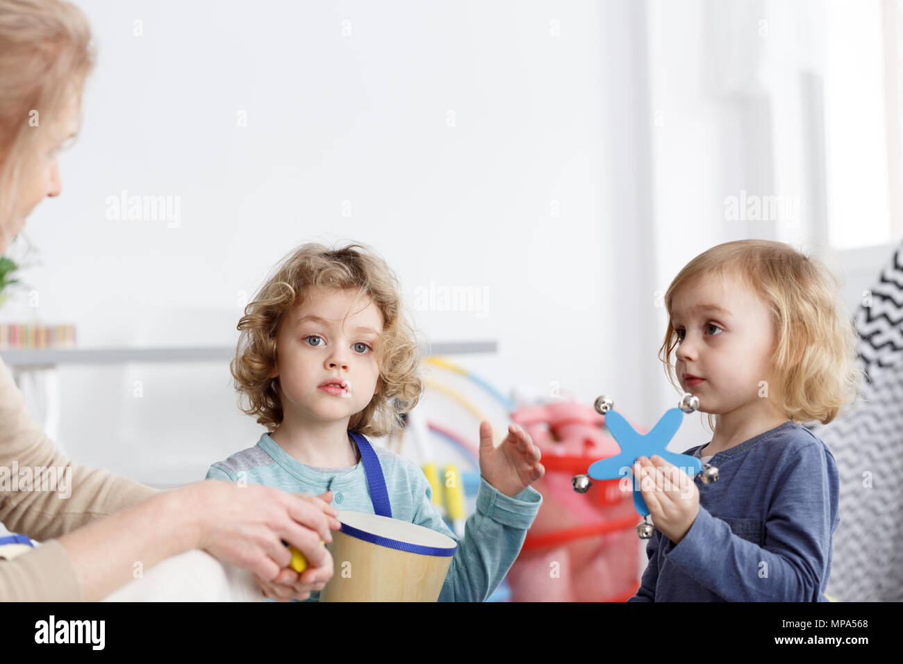 Preschool boy and girl playing the instruments in kindergarten Stock ...