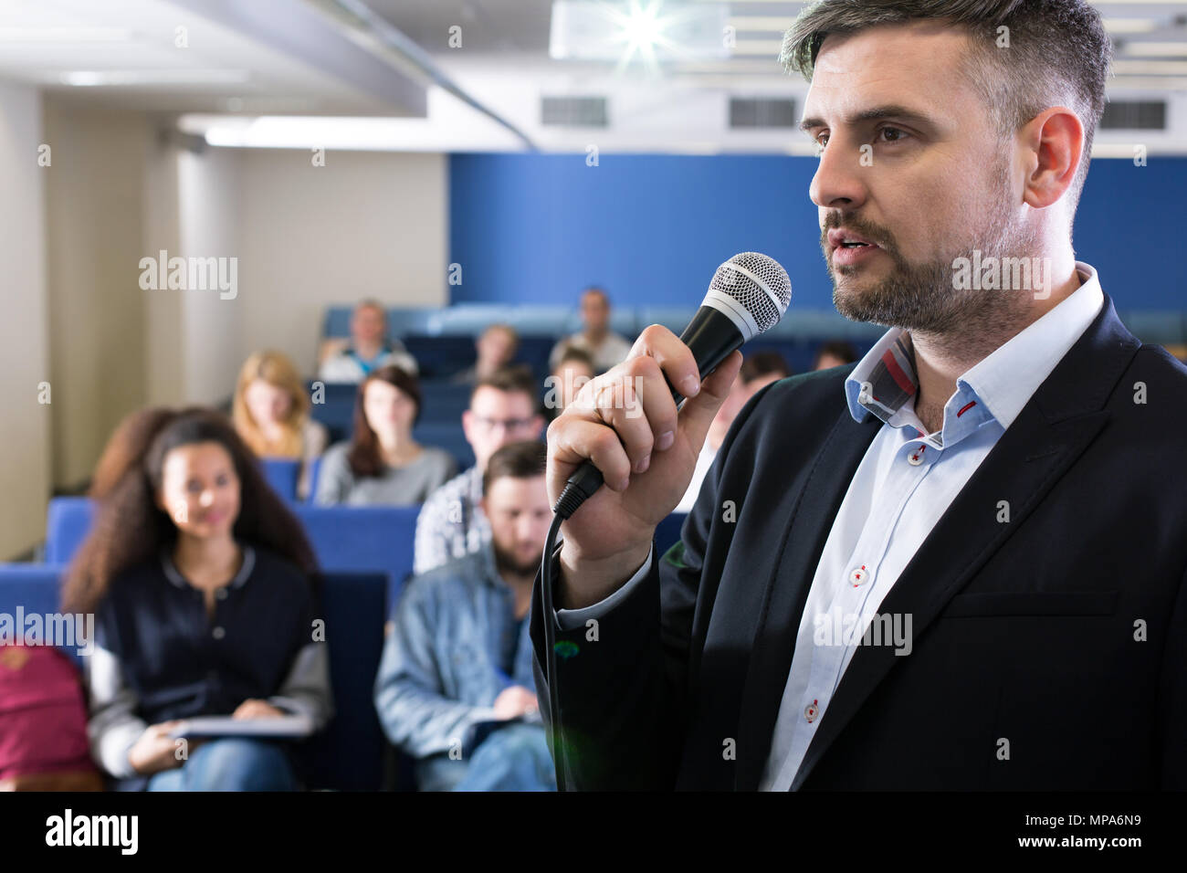 University teacher with microphone giving lecture for students Stock ...