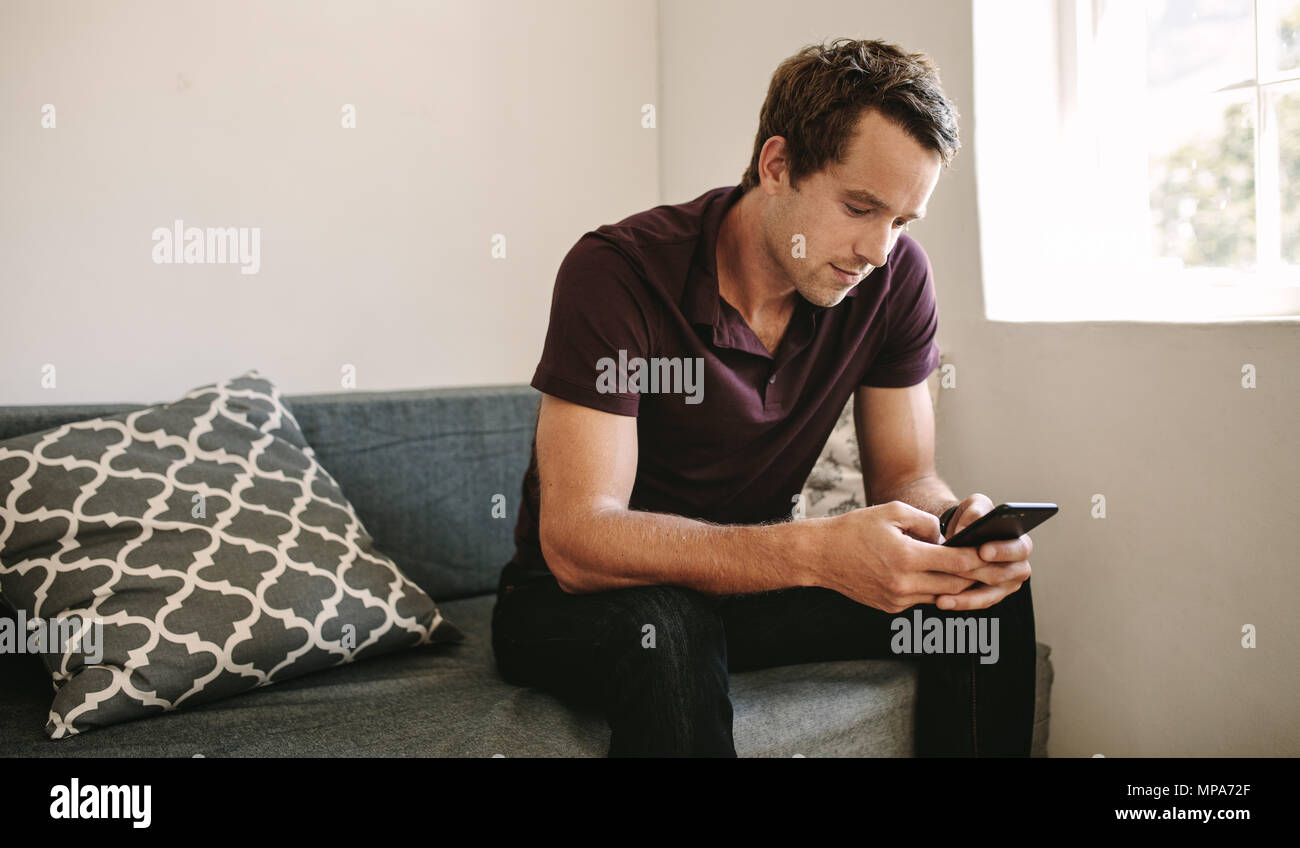 Entrepreneur working on mobile phone sitting in the comfort of home ...