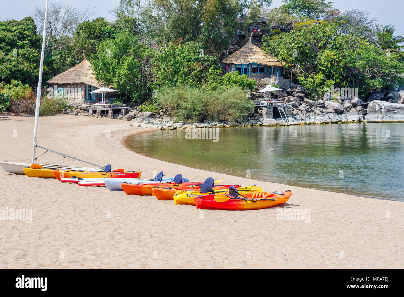 Multi-coloured kayaks for leisure and watersports on the sandy beach ...