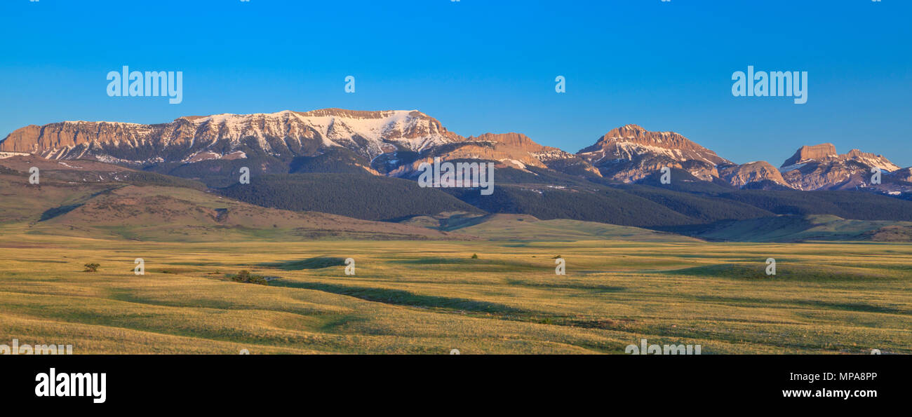 panorama of morning light on peaks of the rocky mountain front above ...