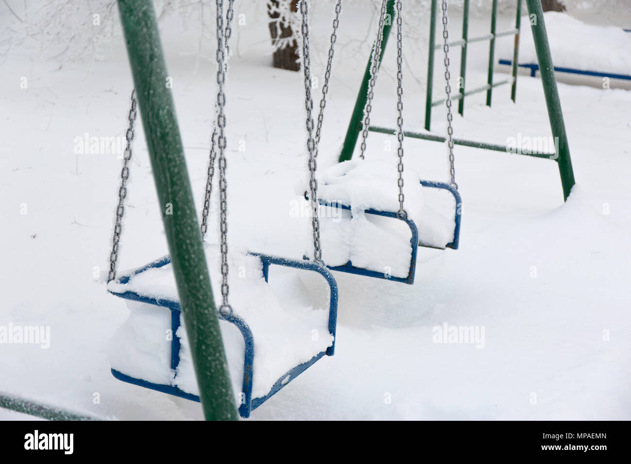 Snow covered swing. Winter children's playground Stock Photo - Alamy